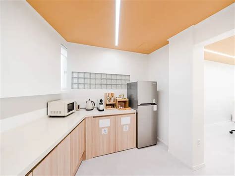 심플한 디자인의 가구들이 깔끔하고 정돈된 사무실 주방 인테리어 사진