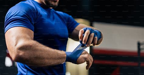 경기장에서 손에 운동 포장 장갑을 끼고 있는 백인 스포츠맨 활동적인 피트니스 트레이너 또는 운동 선수 보디 빌더 남성 운동 체육관 클럽에서 건강 관리를위한 근육 유지를