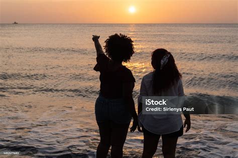 Girls Walking While Holding Her Hands On Sandy Beach And Enjoying