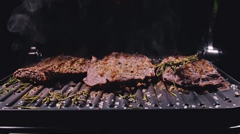 그릴에 맛있는 육즙 고기 스테이크 요리 전기 로스터 로즈마리 후추 소금에 쇠고기 튀김 슬로우 모션 건강한 식생활에 대한 스톡