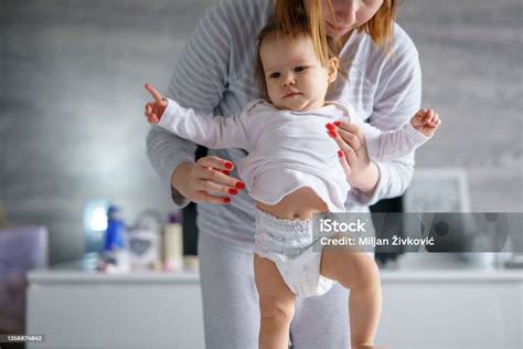 그녀의 어머니가 옷을 입고 실제 사람들이 성장하고 가족 개념 복사 공간을 받고있는 동안 하루에 밝은 방에 침대에 서 있는 백인