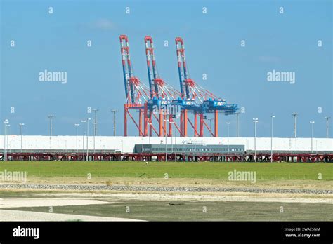 Three Container Loading Cranes In An Industrial Area Behind A Natural Beach Jade Weser