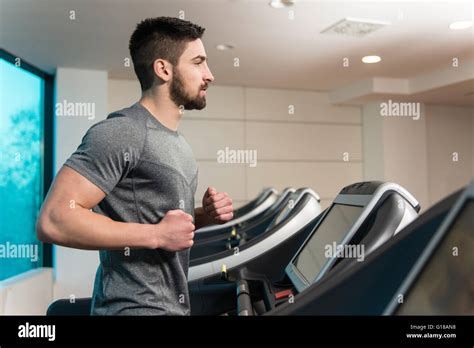 Handsome Man Running On The Treadmill In Gym Stock Photo Alamy