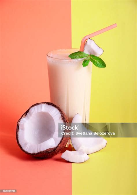 피나 콜라 다파인애플 주스 코코넛 밀크와 럼의 열 대 칵테일 신선한 여름 음료와 함께 금이 간 코코넛과 산호와 노란 배경에 민트 텍스트의 공간 복사 0명에 대한 스톡 사진