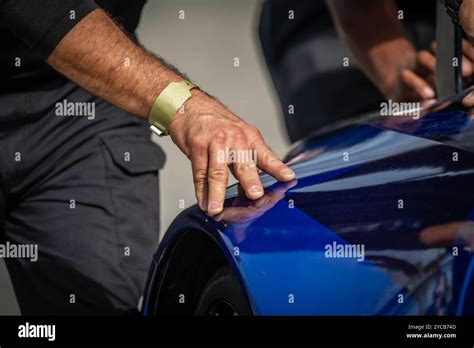 An Engineer Meticulously Inspects The Race Car Fine Tuning Key Components Adjusting