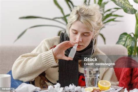 스웨터를 입은 소녀는 소파에 누워 아프다 감기와 독감 환자는 감기에 걸렸고 아프고 코에 방울을 사용합니다 건강에 해로운 소녀 감기와 독감에 대한 스톡 사진 및 기타 이미지