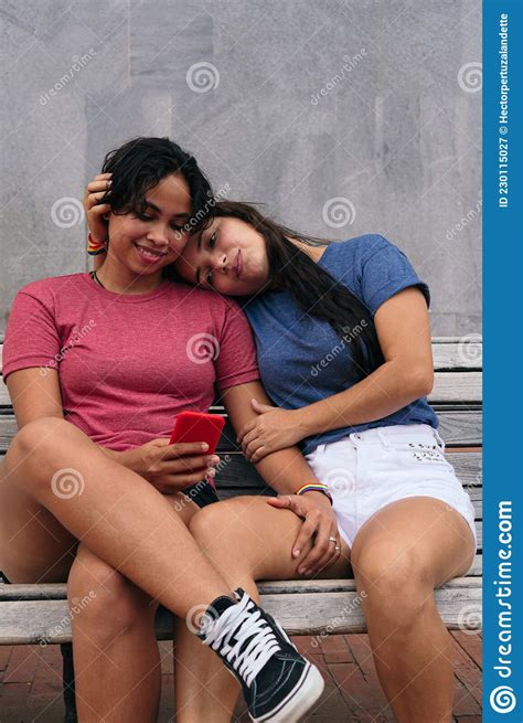 Lesbian Couple Enjoys Tender Moment While Spending Time On A Park Bench