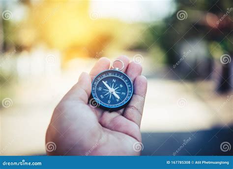 Compass In The Hand Tourists Hold A Compass And Locate A Place Stock
