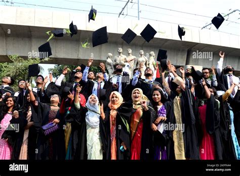 A Group Of Graduates Expressing Their Delight In Front Of The Sculpture