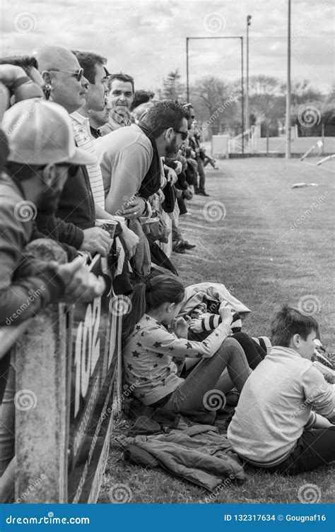 Spectators Watch A Rugby Match On The Side Of A Small French Town`s