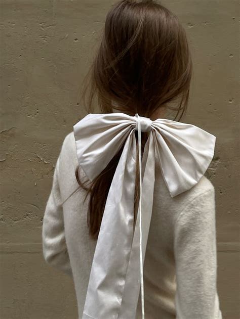 갈색 머리 뒷모습 미니멀리스트 부드러운 빛 부드러운 색조 세련된 복장 수직 쐈어 스타일리시한 시크한 실크 액세서리 실크 활 액세서리 초점 여성 우아한