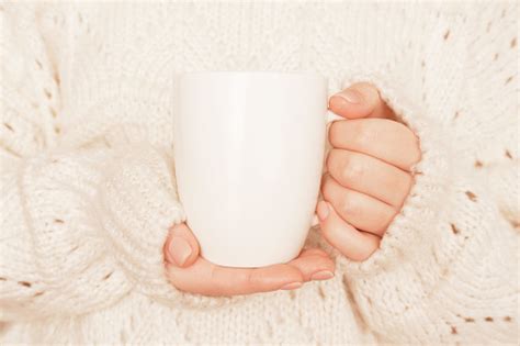 모의 흰 컵을 들고 여자 손 머그잔 클로즈업 흰색 니트 스웨터를 착용하는 여성 빈 템플릿 로고 텍스트 디자인 홍보 문자 메시지 겨울 가을 개념 가을에 대한 스톡 사진 및