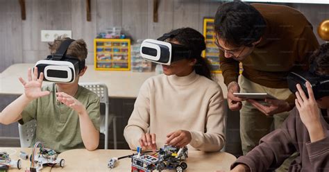 테이블에 앉아 로봇 공학 수업 중에 교사가 도와주는 Vr 안경에 로봇을 투사하는 아이들 사진 Unsplash의 지성 이미지