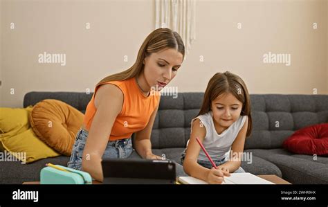 Mother Helps Her Daughter With Homework In A Cozy Living Room