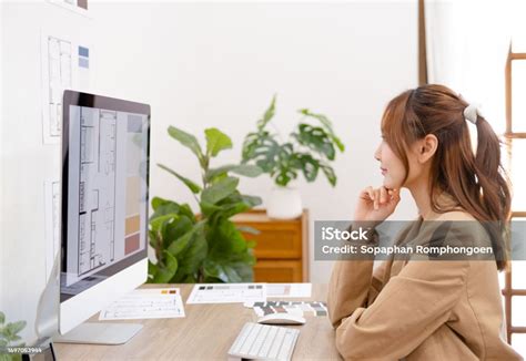 사려 깊은 인테리어 디자이너는 사무실 책상에서 일하면서 컴퓨터 화면을 보고 새로운 인테리어 프로젝트를 위해 디자인을 개발합니다 건축 혁신 스타일 디자인 그래픽입니다 25