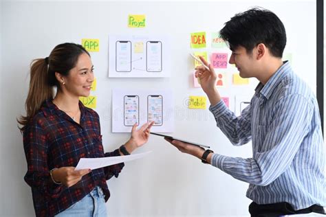 Ux Developer And Ui Designer Brainstorming And Discussing About Mobile App Interface Wireframe