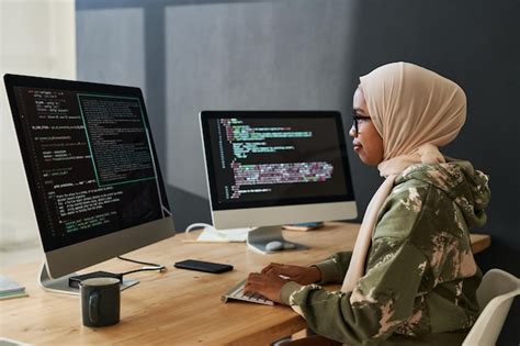 Premium Photo Side View Of Young Muslim Female Programmer Looking Through Coded Information On