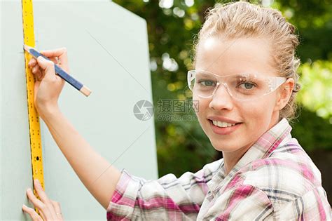 妇女用铅笔测量胶合板和标记高清图片下载 正版图片501507507 摄图网