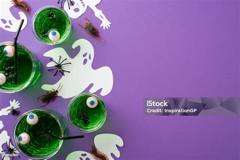 할로윈 파티 개념 녹색 떠 다니는 눈을 가진 안경의 탑뷰 사진 펀치 해골 유령 실루엣 거미 지네와 바퀴벌레가 빈 공간이있는 고립 된 보라색 배경에 0명에 대한 스톡 사진 및