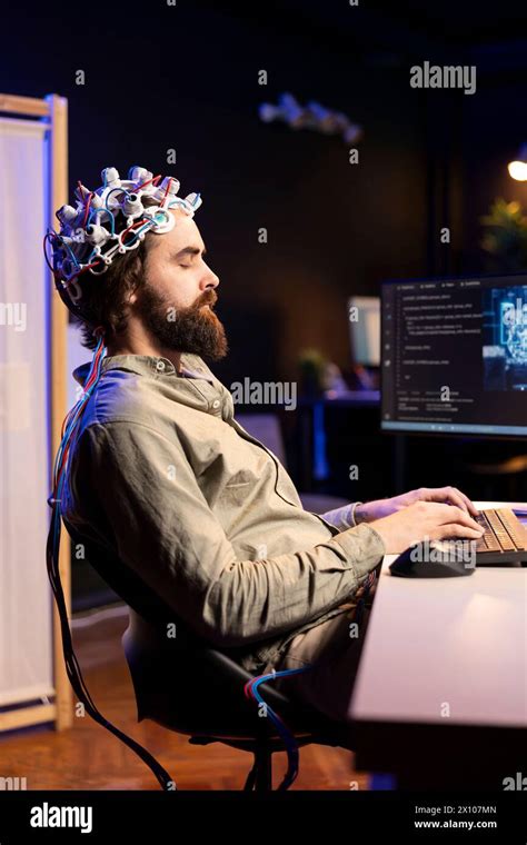 Man With Eeg Headset On Typing On Keyboard Writing Code Allowing Him