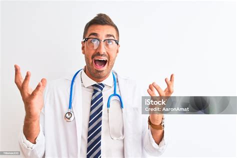 고립 된 배경에 청진기를 입고 젊은 잘 생긴 의사 남자는 미친 미친 미친 소리와 공격적인 표정과 팔을 제기 고함 좌절 개념입니다 감정에 대한 스톡 사진 및 기타 이미지