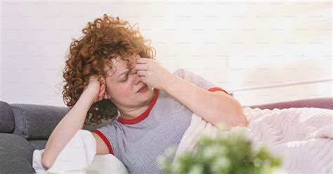 화가 우울한 젊은 여자는 소파에 누워 강한 두통 편두통 슬픈 피곤한 졸린 십대 지친 소녀 긴장과 스트레스 후 잠을 자려고 쉬고