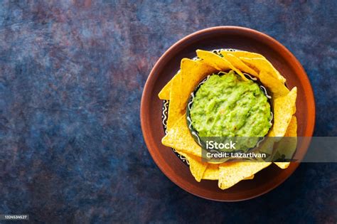 점토 그릇에 토르티야 칩을 곁들인 전통적인 멕시코 소스 과카몰리 어두운 배경에 나초 칩과 과카몰리의 그릇 공간을 복사합니다 위쪽 보기 0명에 대한 스톡 사진 및 기타 이미지