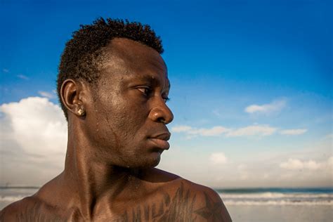 머리와 어깨를 닫습니다 젊은 매력적이 고 적합 흑인 아프리카계 미국인 남자 강한 근육 질의 몸 포즈 시원한 모델 태도 해변에 고립 된 여름 푸른 하늘 30 39세에 대한