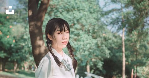 흰 셔츠와 검은 색과 흰색 격자 무늬 치마를 입은 여자가 푸른 잔디 밭에 서 있습니다 사진 Unsplash의 무료 회색 이미지