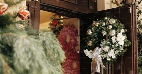 크리스마스 거리 장식입니다 도시 거리의 휴일 시장에서 앞 상점의 문에 은색 장식품이 있는 세련된 크리스마스 화환 텍스트를 위한 공간입니다 소박한 장식 사진