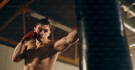 체육관에서 스포츠 훈련 중 권투 가방을 펀칭하는 젊은 전투기의 낮은 각도 보기 사진 Unsplash의 싸움 이미지