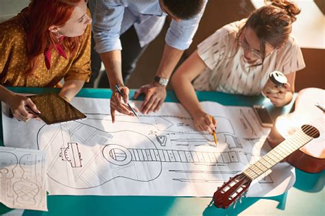 사무실에서 젊은 디자이너 그룹은 새로운 기타 디자인을 논의 직원 사무실 직장 20 29세에 대한 스톡 사진 및 기타 이미지 20 29세 Staff Meeting 계획