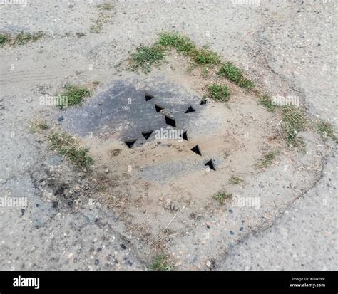 The Drain Hatch Amid The Asphalt Hatch With Holes Stock Photo Alamy