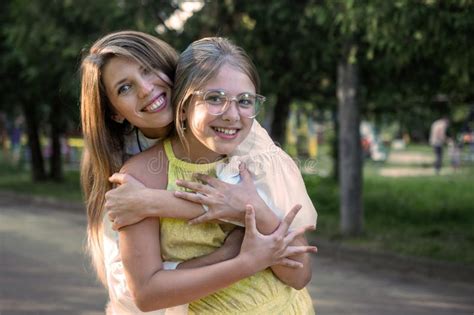 Cheerful Portrait Of A Young Woman And Her Teenage Daughter Mother And