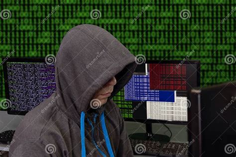 a hacker sits behind computer monitors on an abstract background attacking and hacking servers