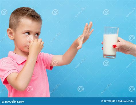 Il Bambino Si Stringe Il Naso Con La Mano E Si Rifiuta Di Bere Il Latte Fotografia Stock