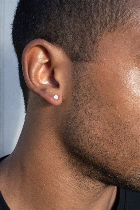 A Close Up Of A Man With An Ear Piercing On His Left Side And The Top Part Of His Head