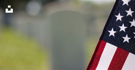 배경에 묘지가 있는 미국 국기의 클로즈업 사진 Unsplash의 무료 기 이미지