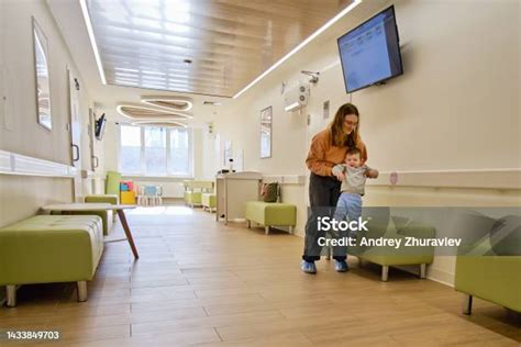 병원에서 여자 어머니와 함께 의사의 약속을 기다리는 행복한 유아 아기 소아과 의사를 받기 전에 현대 병원에서 아기를 안고 있는 엄마 1세 3개월 된 아이 건강관리와 의술에