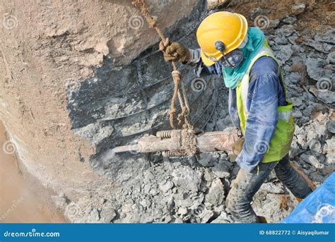 A Construction Workers Hacking Foundation Pile Editorial Photography