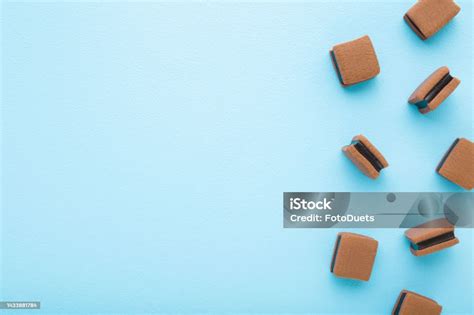 밝은 파란색 테이블 배경에 다크 초콜릿을 곁들인 브라운 젤리 구미 사탕 파스텔 색상 달콤한 스낵 근접 촬영 텍스트의 빈 위치입니다 하향식 보기 갈색에 대한 스톡 사진 및