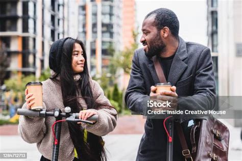 도시 지역에서 전기 스쿠터를 타고 커피 한 잔을 들고 멋진 25 S 혼합 인종 커플 20 24세에 대한 스톡 사진 및 기타 이미지 20 24세 25 29세 2명