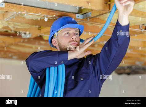 Male Builder Installing Pipes In The Ceiling Stock Photo Alamy