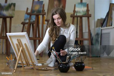 여성 예술가가 예술 스튜디오에서 그림을 그리는 이젤 사이에 바닥에 앉아 캔버스에 유화를 그립니다 30 39세에 대한 스톡 사진 및 기타 이미지 Istock