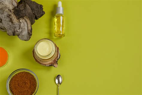 차가 자작나무 버섯은 화장품의 유행 개념입니다 천연 크림 노란색 배경에 유리 용기에 차가와 에센셜 오일 스파 천연 항산화제 플랫 레이 공간을 복사합니다 개념에 대한 스톡