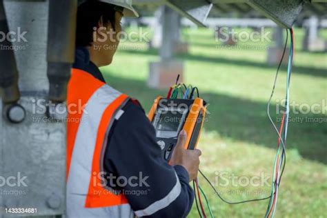 엔지니어들은 성능 검사기로 태양 전지판을 점검하여 각 태양 전지 패널이 최대 효율로 작동하는지 확인합니다 세계의 에너지를 보존하기위한 대체 에너지 재생 가능 사업 태양