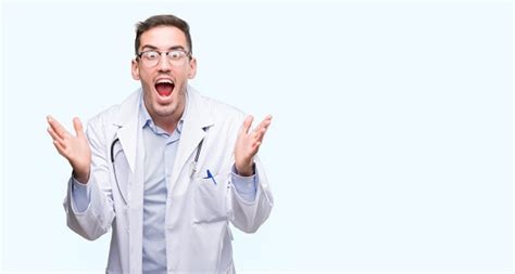 잘생긴 젊은 남자 축 하 미친 의사 하 고 무기와 성공을 위한 놀 제기 및 오픈 눈 비명 흥분 우승자 개념 건강관리와 의술에 대한 스톡 사진 및 기타 이미지 Istock