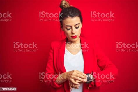 빨간 고립 된 배경 위에 서있는 젊은 아름다운 비즈니스 여성 손목 시계에 시간을 확인 편안하고 자신감 가리키기에 대한 스톡 사진 및 기타 이미지 Istock