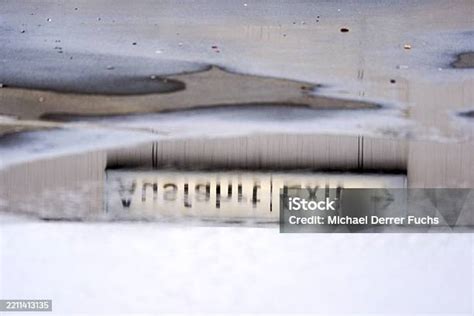 회색 겨울 날에 스위스 공항 취리히 클로텐의 주차 데크 옥상에 조명이 켜진 출구 방향 표지판의 물 웅덩이의 반사의 높은 각도의보기 0명에 대한 스톡 사진 및 기타 이미지