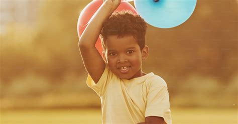 손에 풍선을 들고 아프리카 계 미국인 아이는 여름 낮에 들판에서 재미를 느낍니다 사진 Unsplash의 열광 이미지